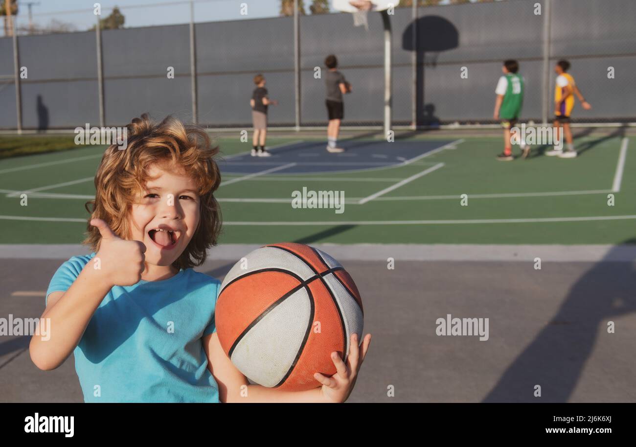 Little caucasian sports kid playing basketball holding ball with happy ...