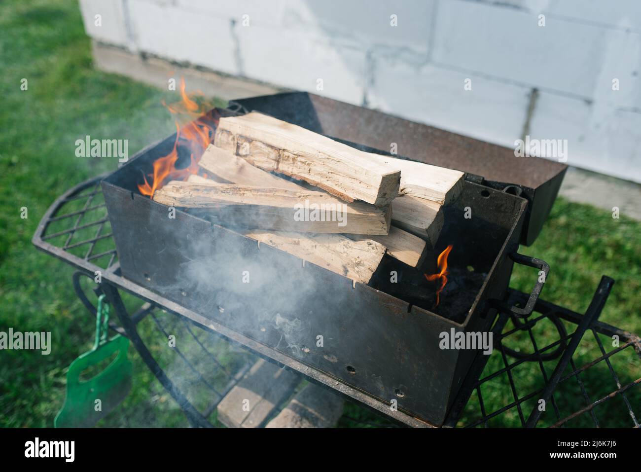 Firewood burns on a barbecue grill Stock Photo - Alamy