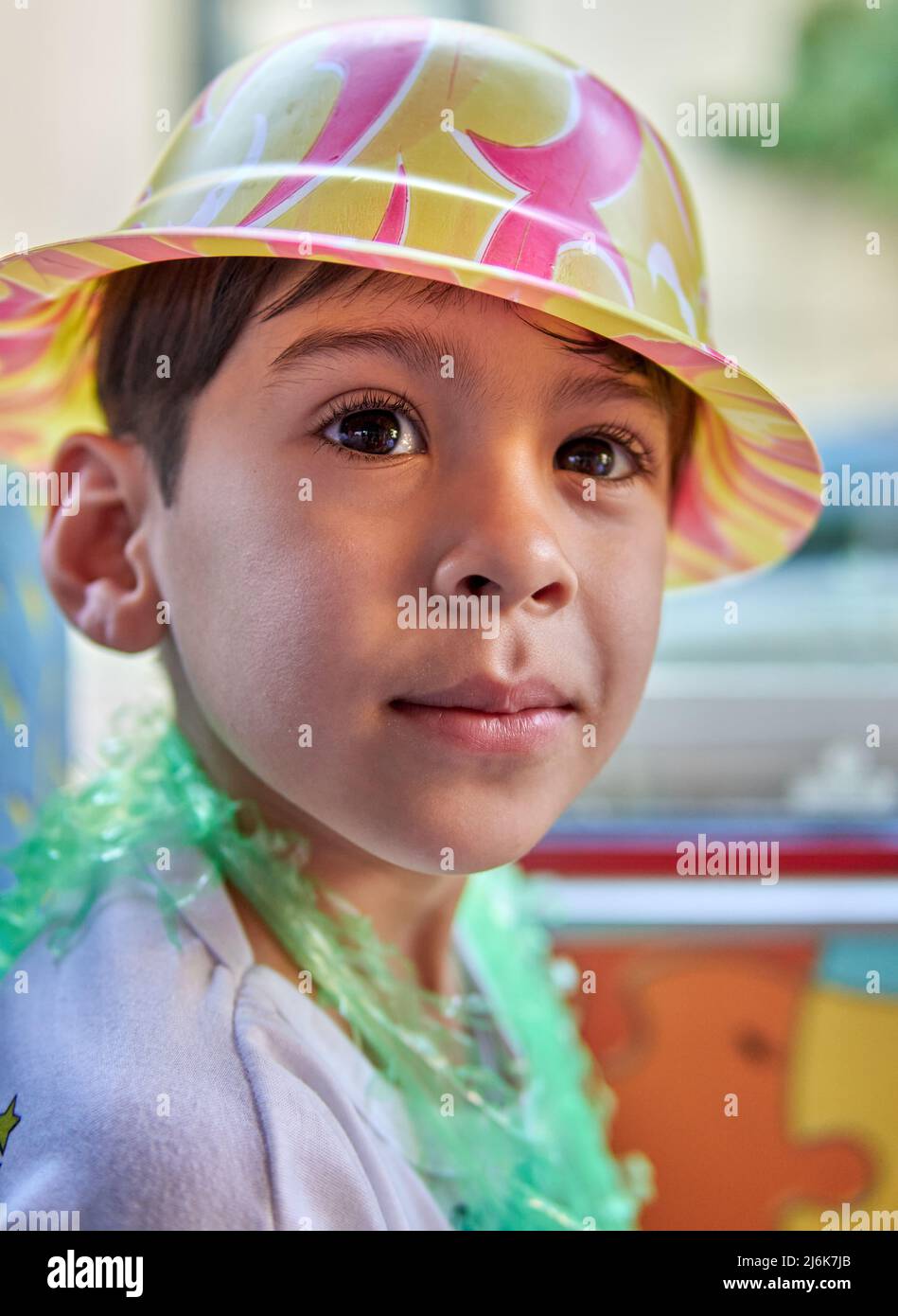 portrait of brown Latino boy with smiling face and a party hood and ...