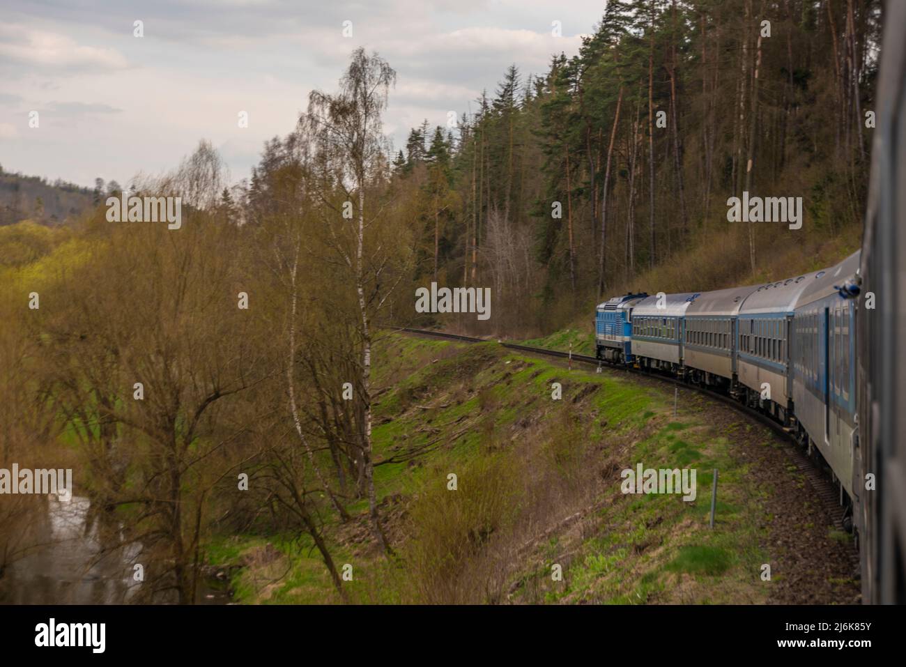 Blue diesel locomotive and blue passenger coach near Jihlava town in ...
