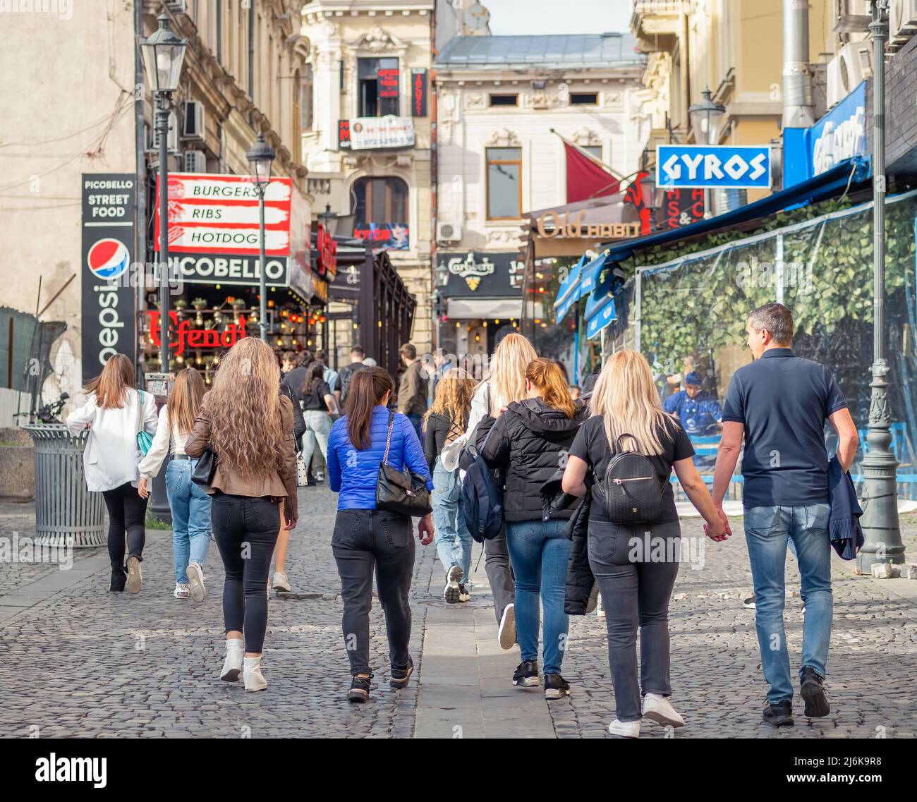 Bucharest, Romania - 04.08.2022:Rear view with a group of young tourist ...