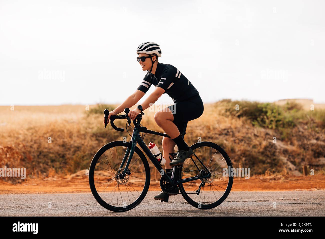 Side view of professional woman cyclist riding her bike outdoors Stock ...