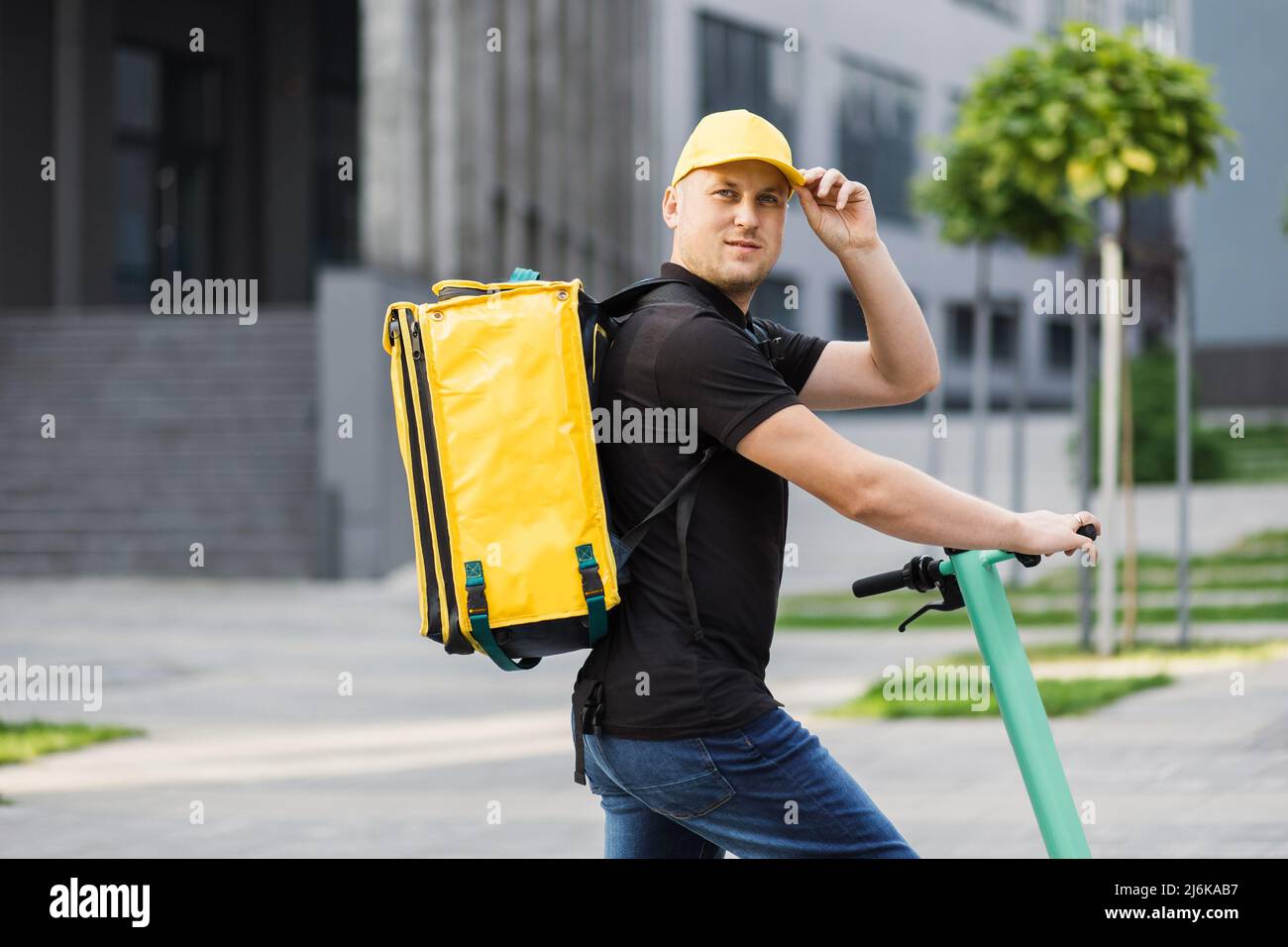 Courier deliver food on electric scooter. Boy delivering hot food to ...