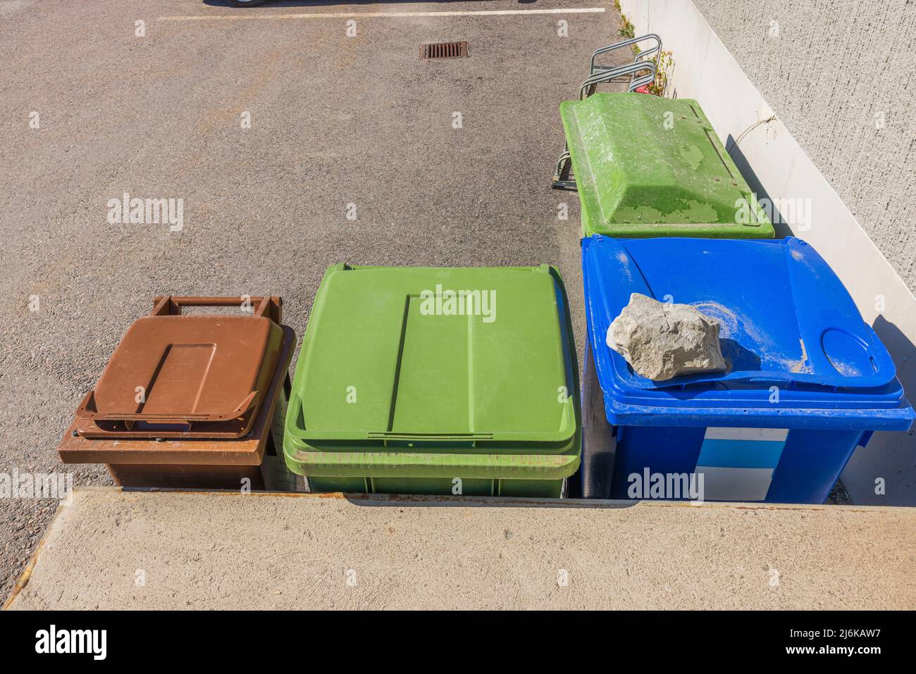 Close-up top view of three garbage sorting bins and sand container ...