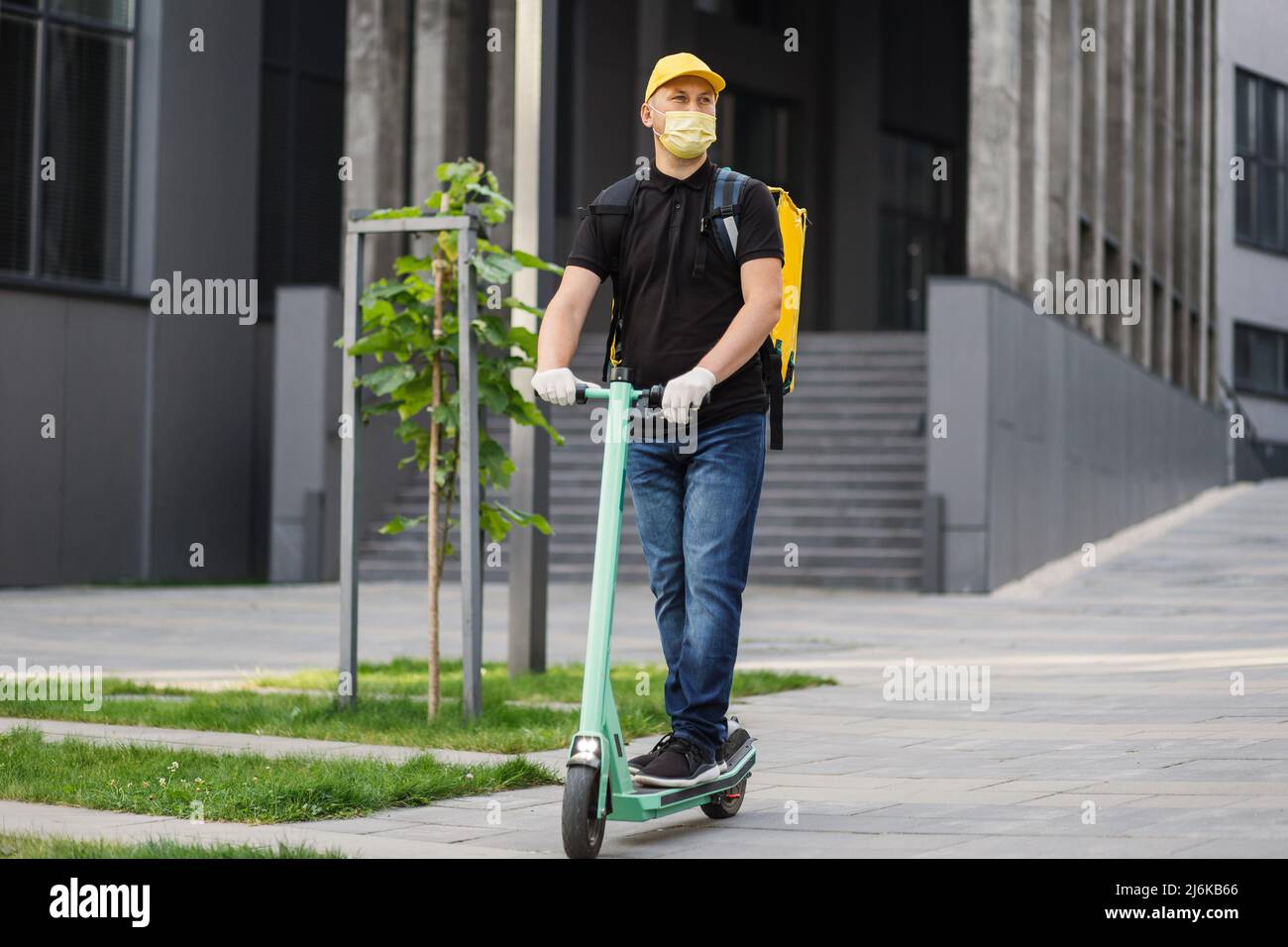 Man courier food delivery with yellow face mask and thermal backpack ...