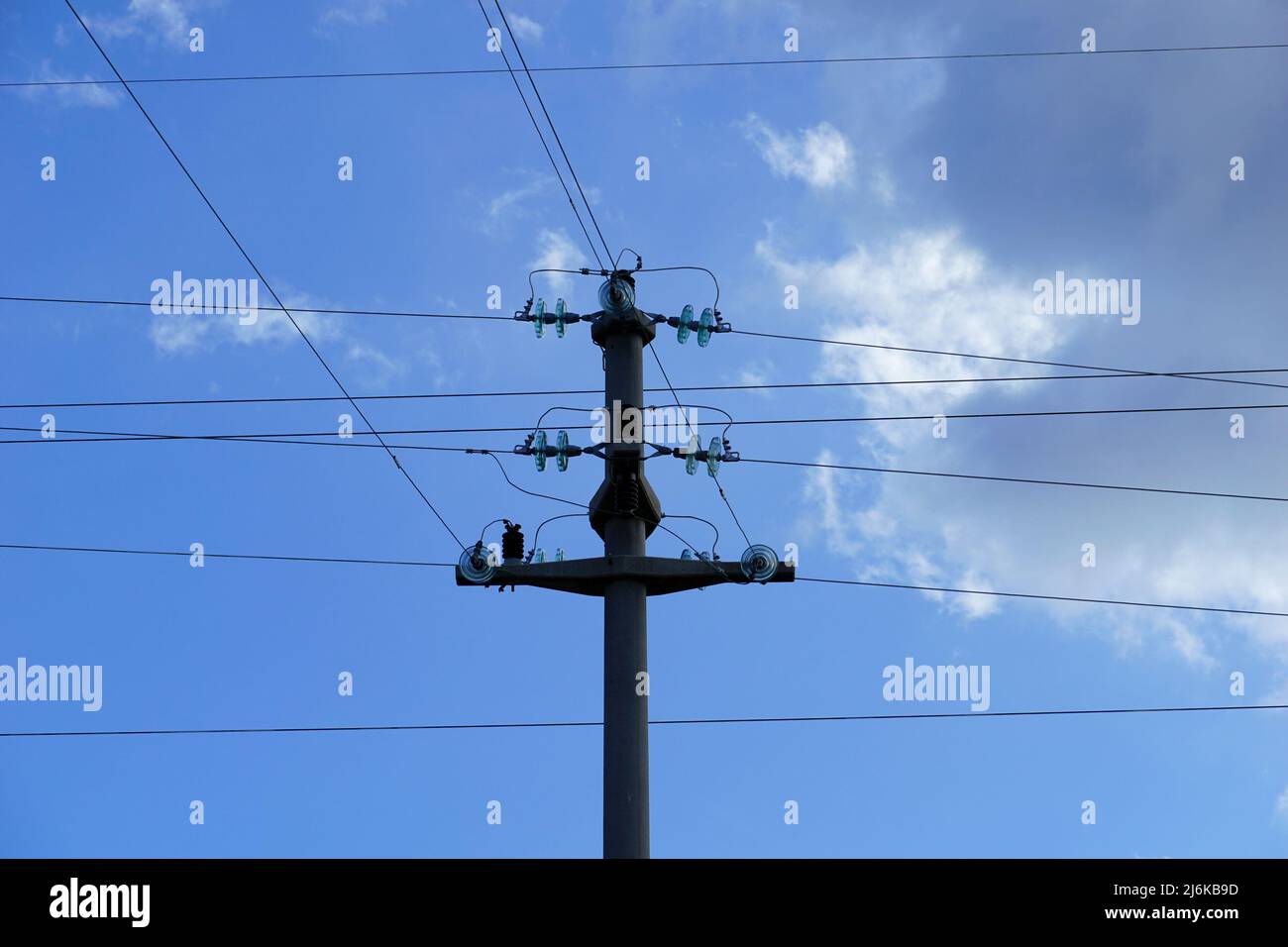 Power line pole with wires that conduct electricity in front of blue ...