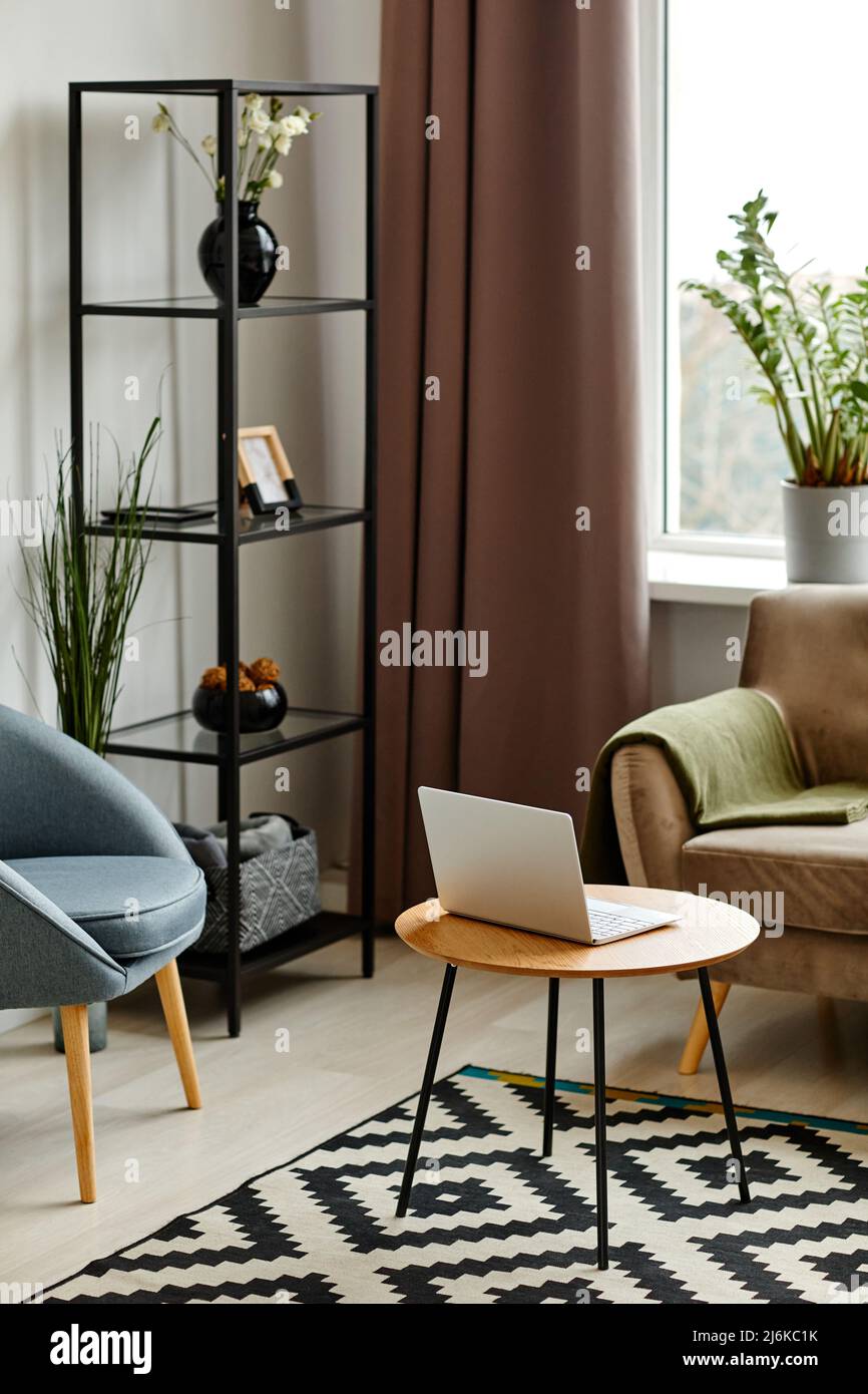 Vertical image of modern living room interior with open laptop by ...