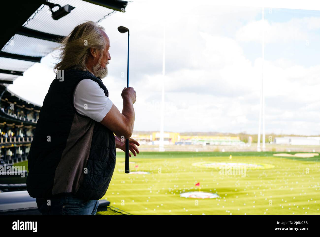 Senior man playing golf in modern golf location Stock Photo - Alamy