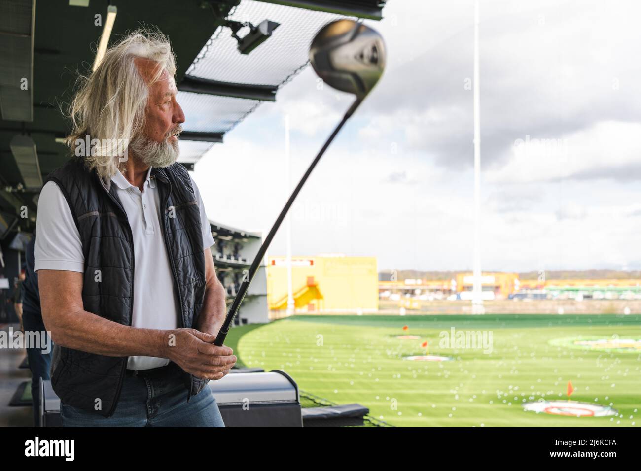 Senior man playing golf in modern golf location Stock Photo - Alamy