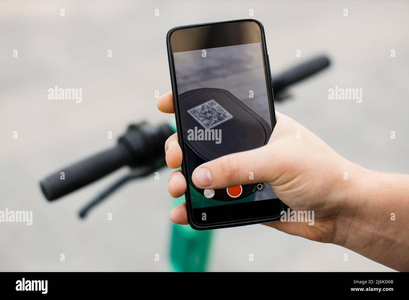 Hand of unrecognizable man using smartphone for renting modern electric ...