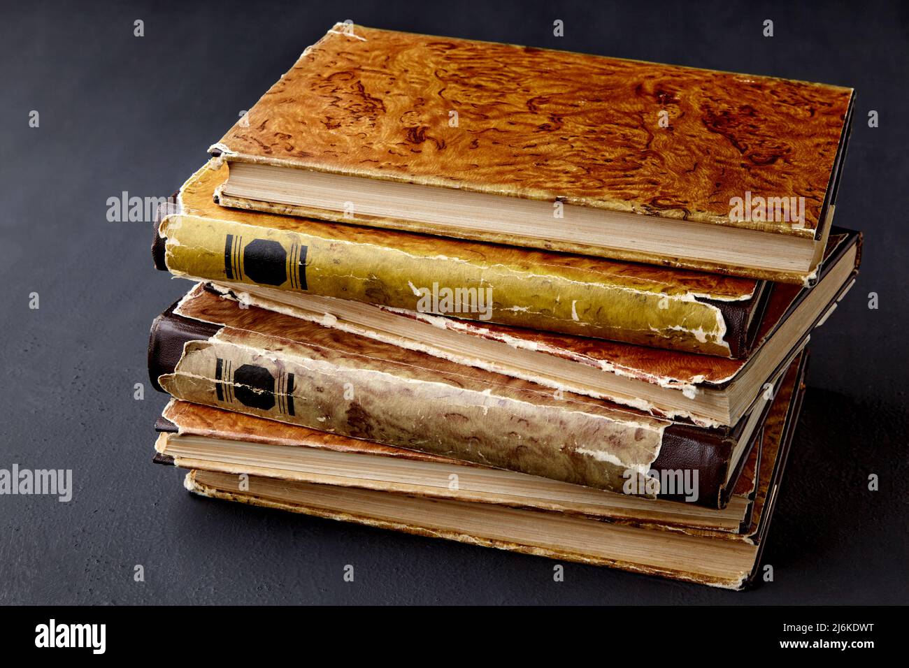 A stack of vintage dilapidated books on a dark concrete table Stock ...