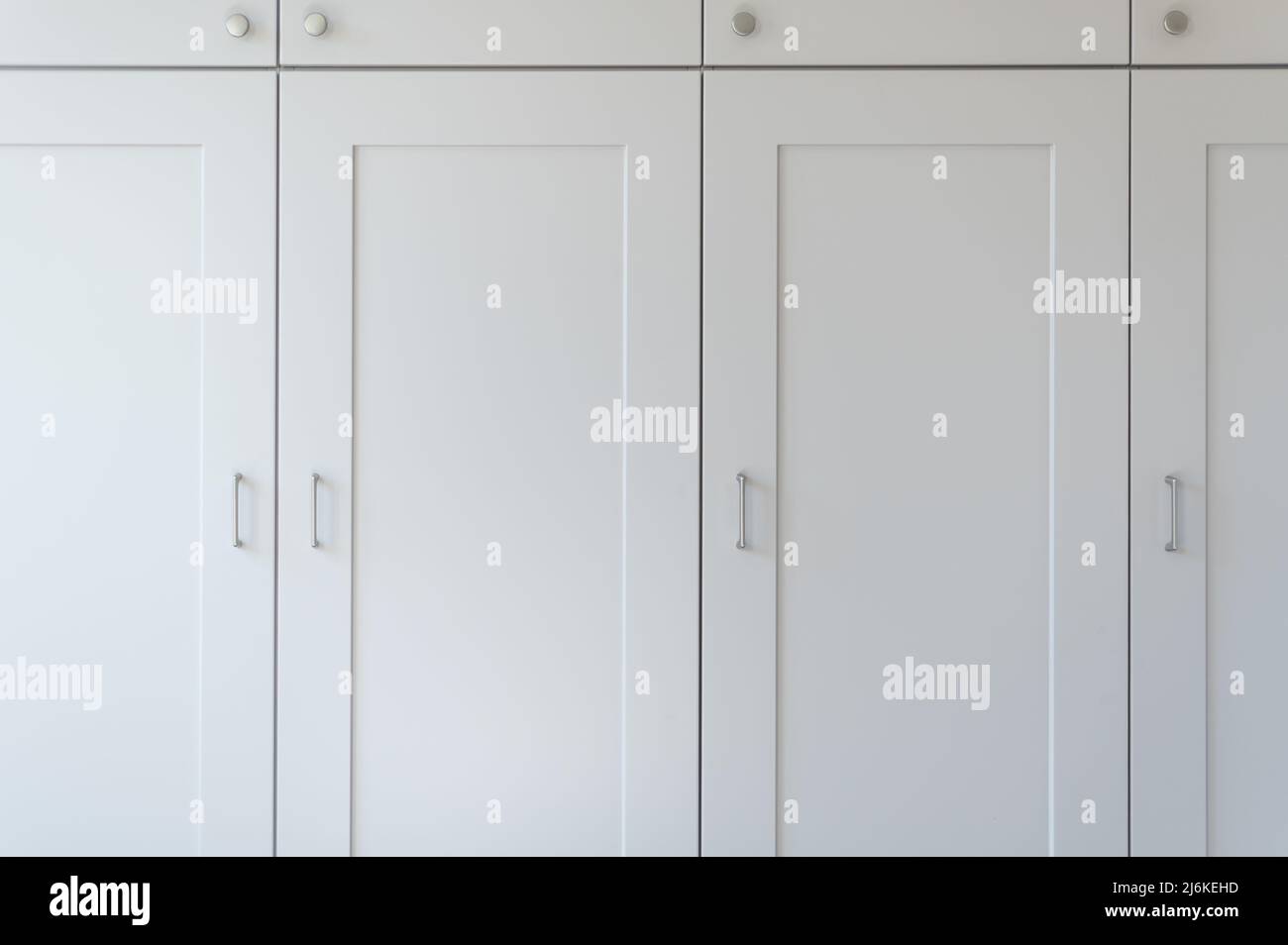 Modern new fitted tall cupboards in kitchen light grey color, interior ...