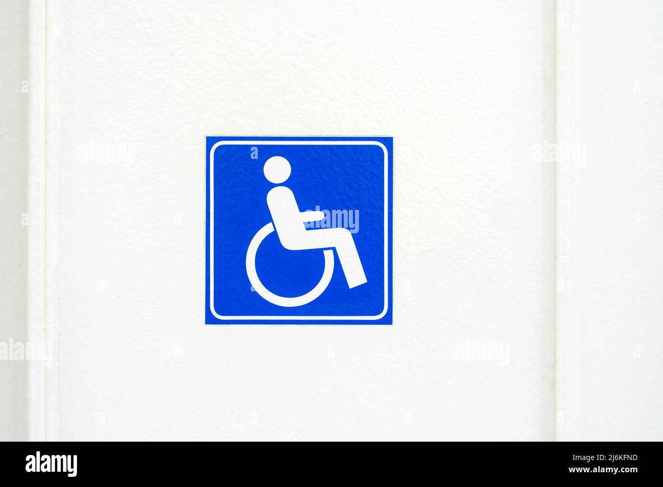 Simple square wheelchair symbol sticker, label on a white wall, people ...