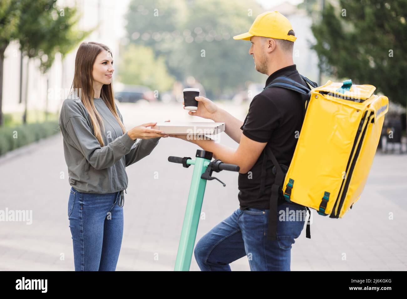 Girl ordered delivery of pizza. Attractive young delivery guy holding ...