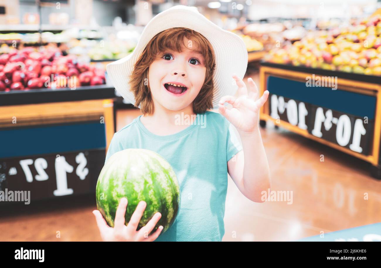 Portrait of child hold watermelon in grocery shopping in supermarket ...