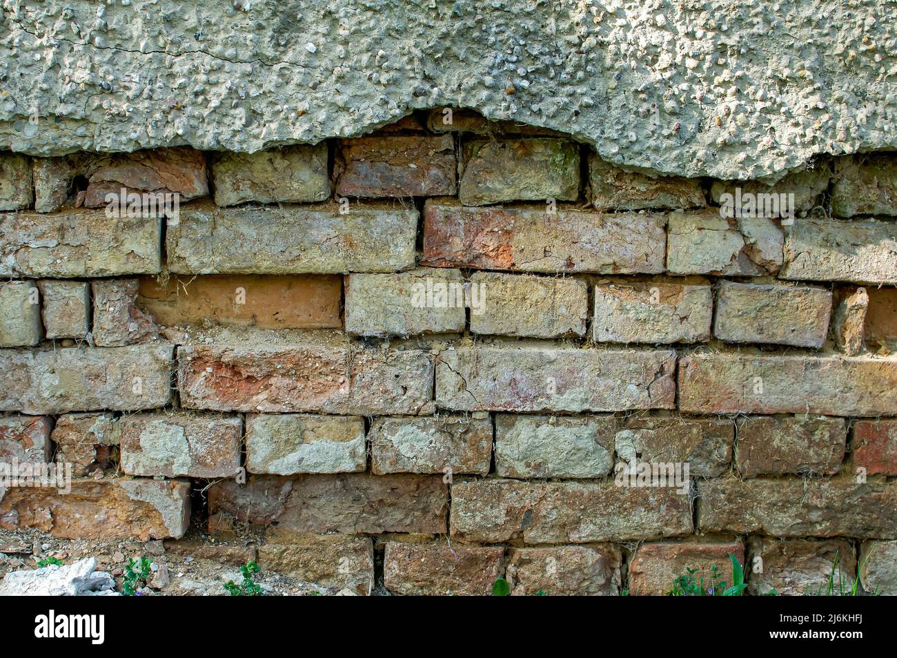 texture of an old wall, a wall made of damaged colored brick, with ...