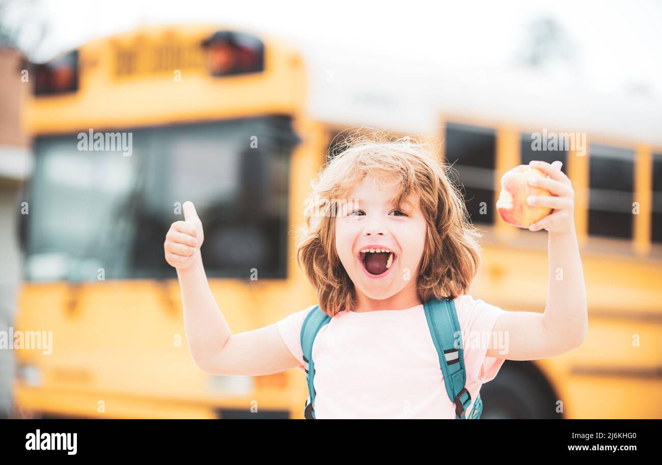 Child getting on school bus. Child with positive gesture with hand ...