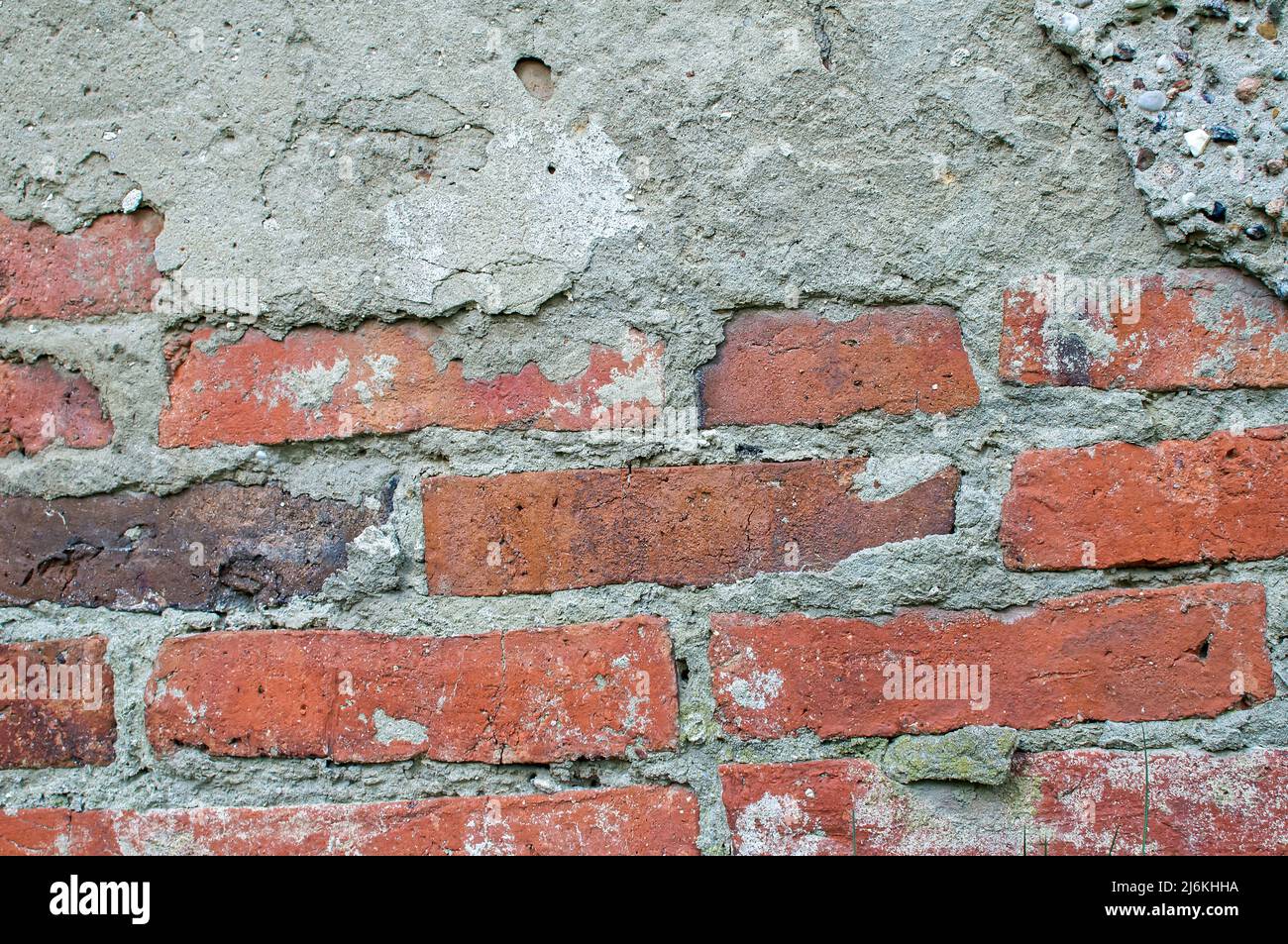 texture of an old wall, a wall made of damaged colored brick, with ...