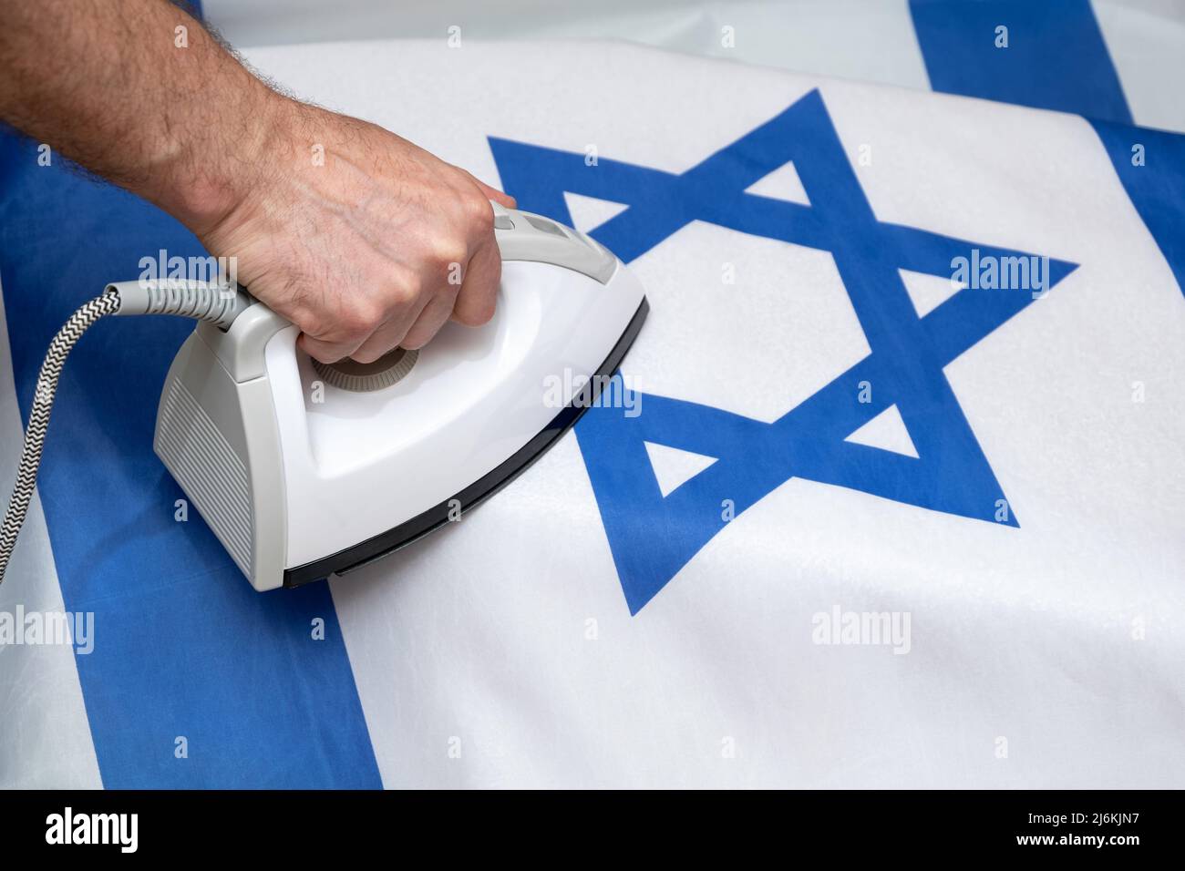Patriot ironing Israeli national flag, state Israel on Independence day ...