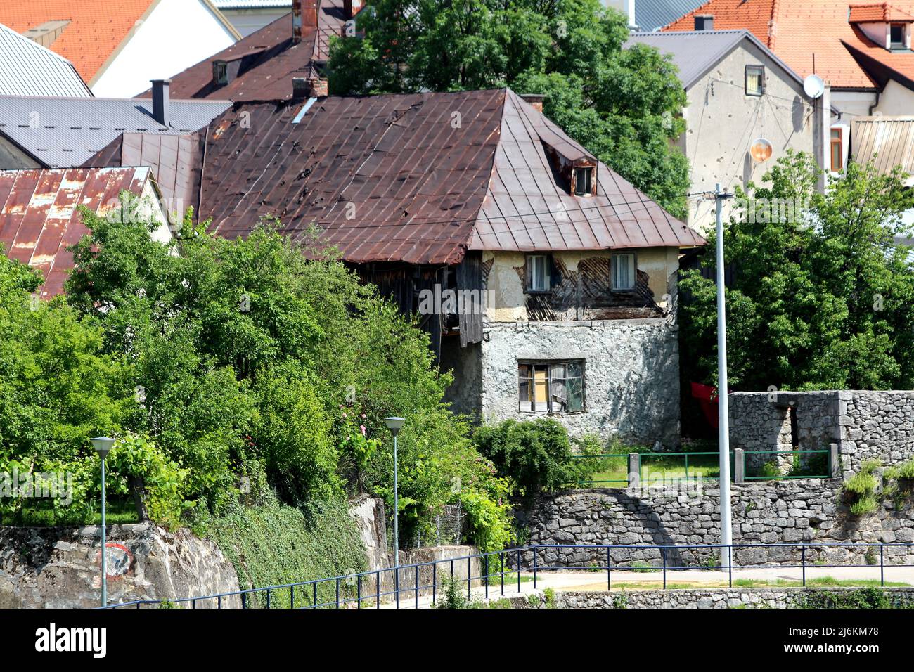 Abandoned traditional stone and wood suburban family house with boarded broken windows and ...