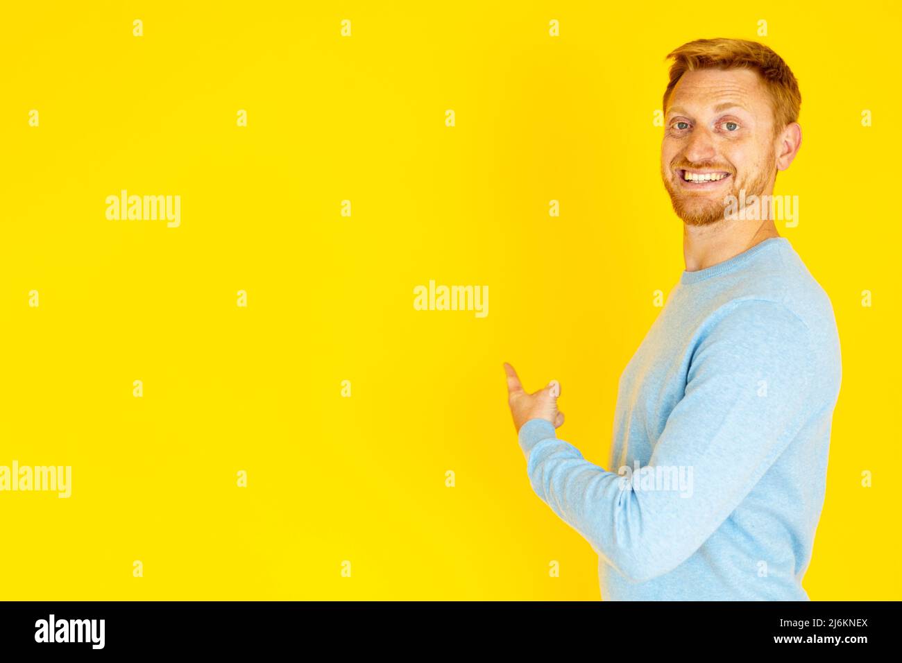 Smiling young guy pointing finger hi-res stock photography and images ...