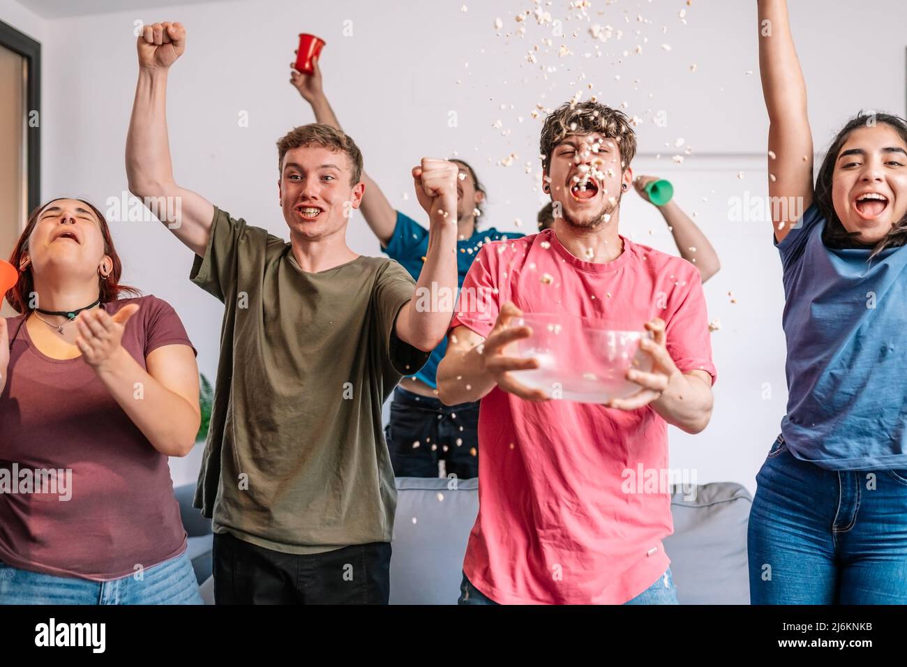young people screaming with excitement throwing popcorn in the air ...