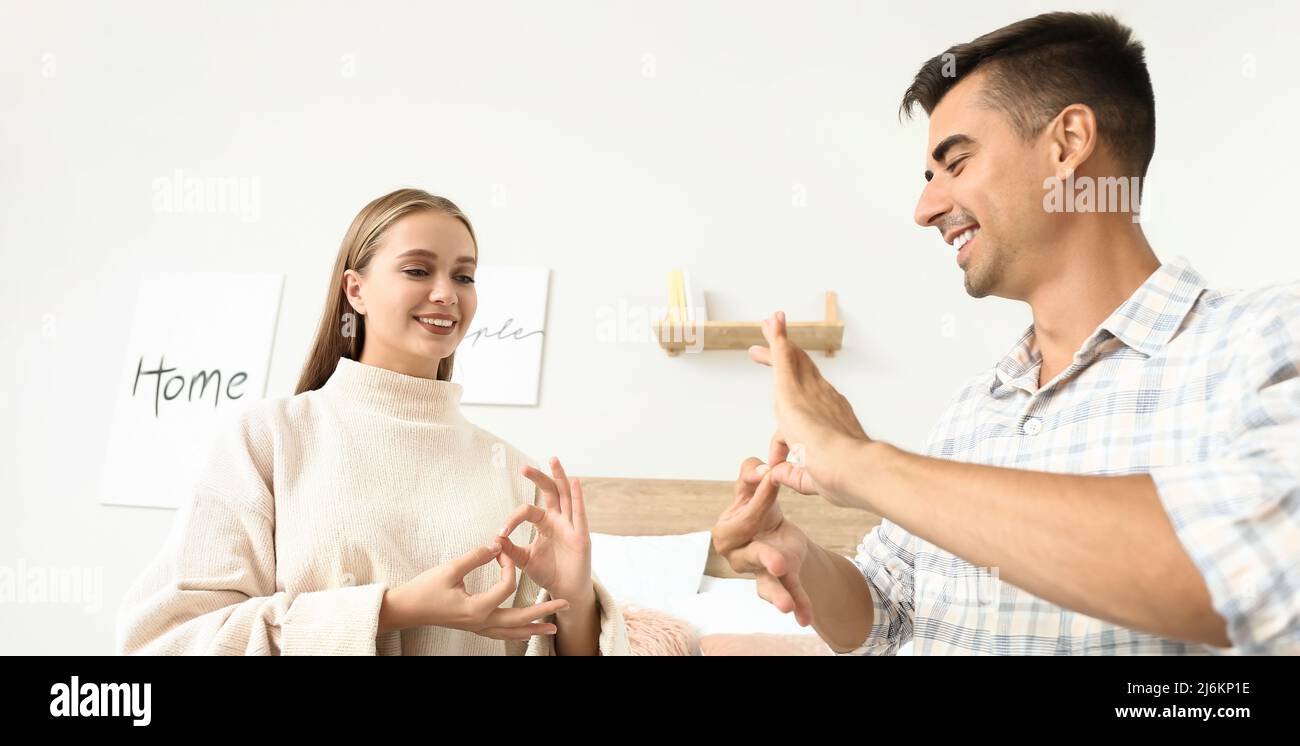Young deaf mute couple using sign language at home Stock Photo - Alamy