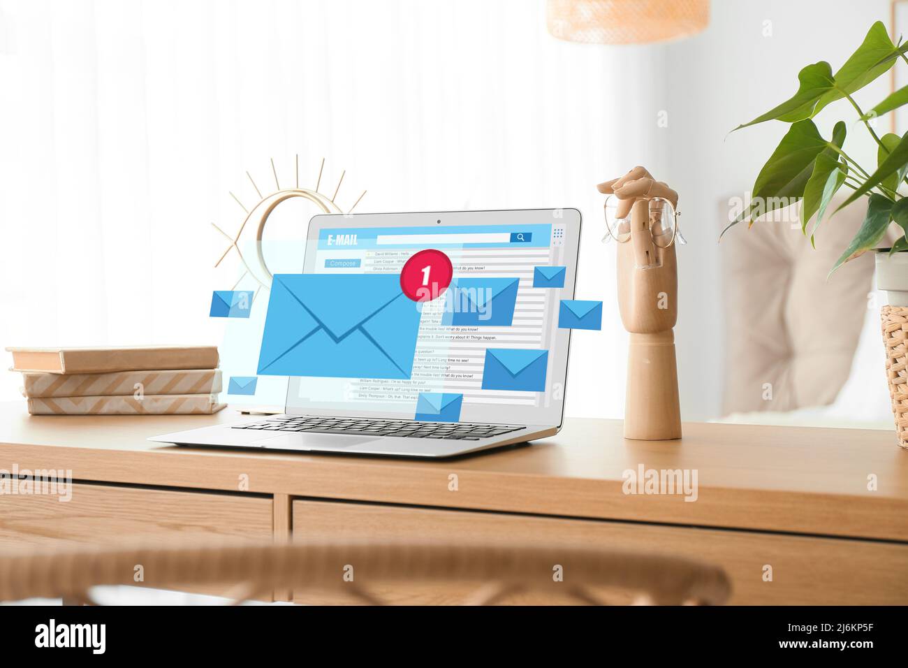 Modern laptop with symbols of new unread messages on screen in room ...