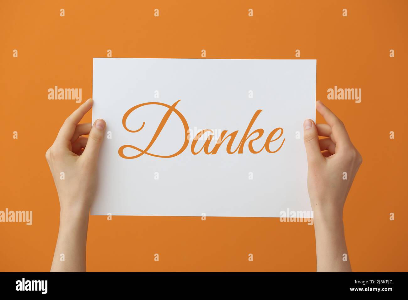 Female hands holding paper with word DANKE (German for Thanks) on ...