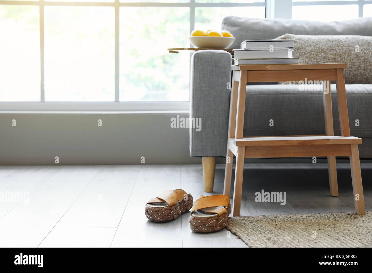 Wooden step ladder with sofa, books and female shoes in interior of ...