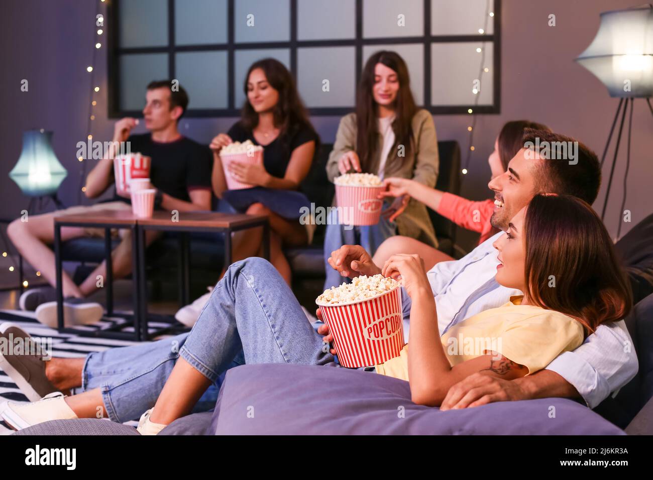 Group of friends watching movie at home in evening Stock Photo - Alamy