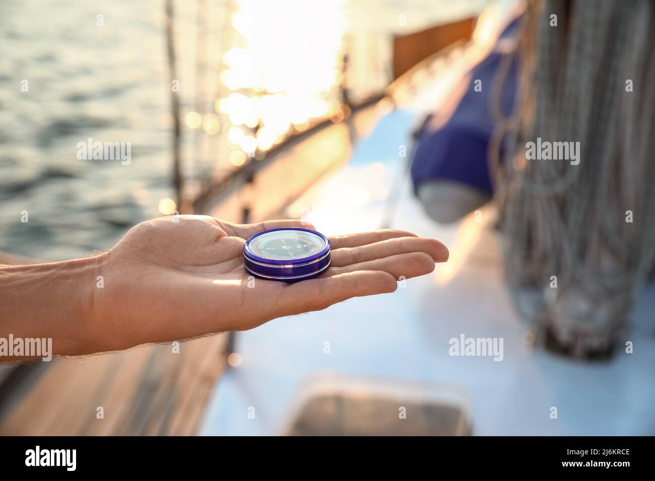 Hand of captain with compass on yacht Stock Photo - Alamy