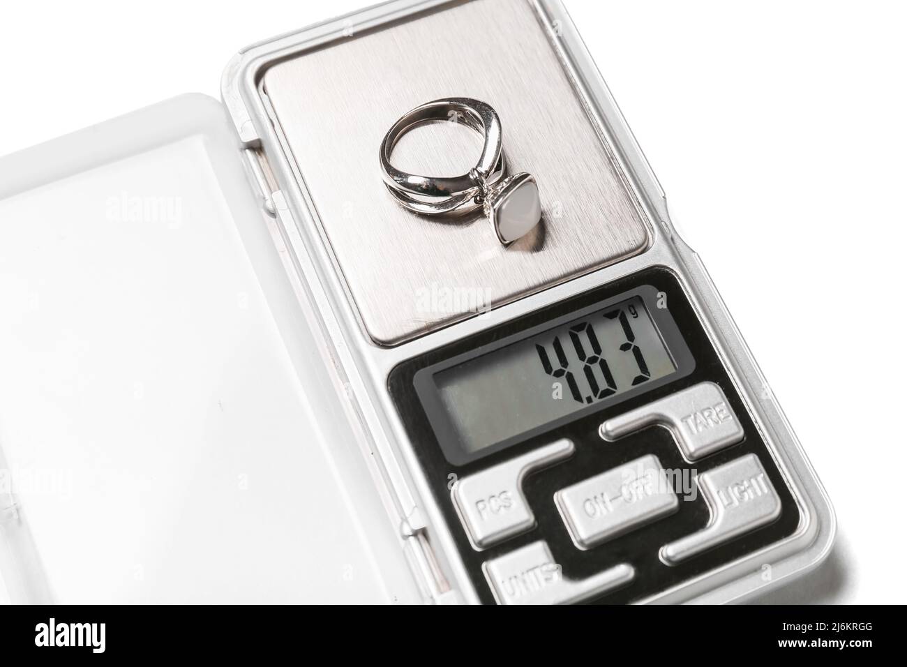 Jewelry scales with ring on white background Stock Photo - Alamy