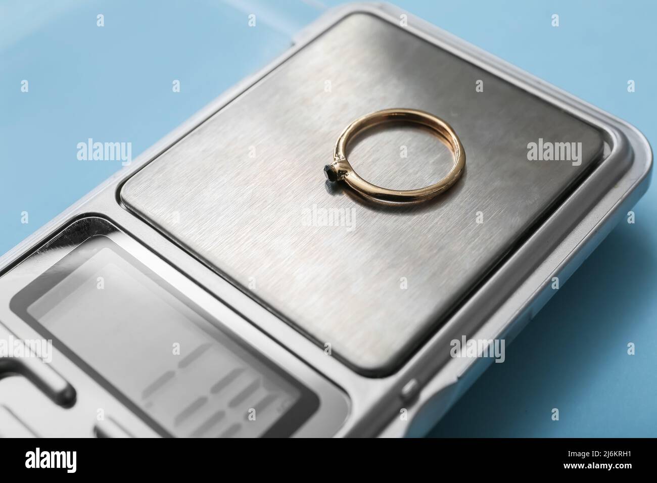 Jewelry scales with ring on blue background, closeup Stock Photo - Alamy