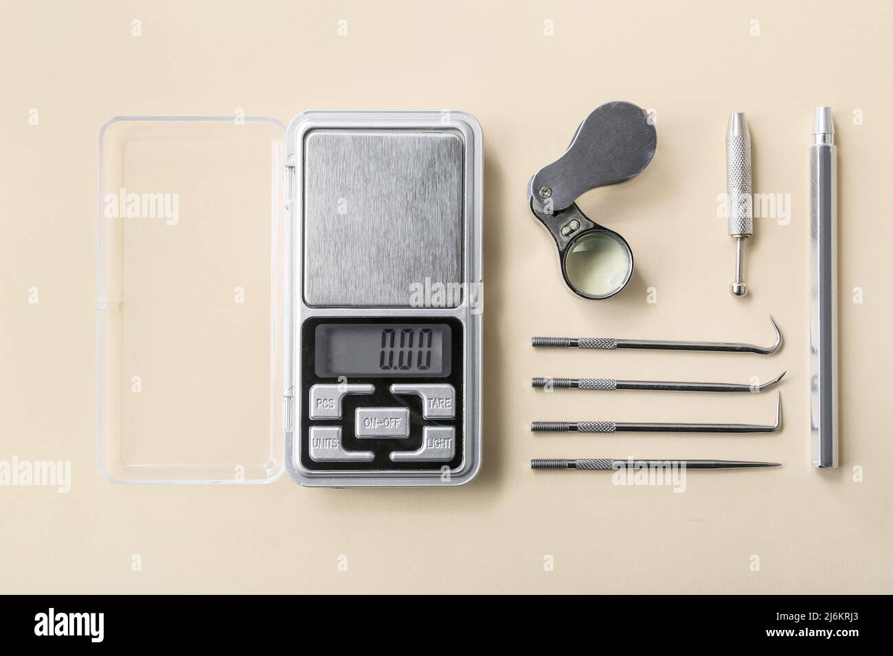 Jewelry scales with different tools on beige background Stock Photo - Alamy