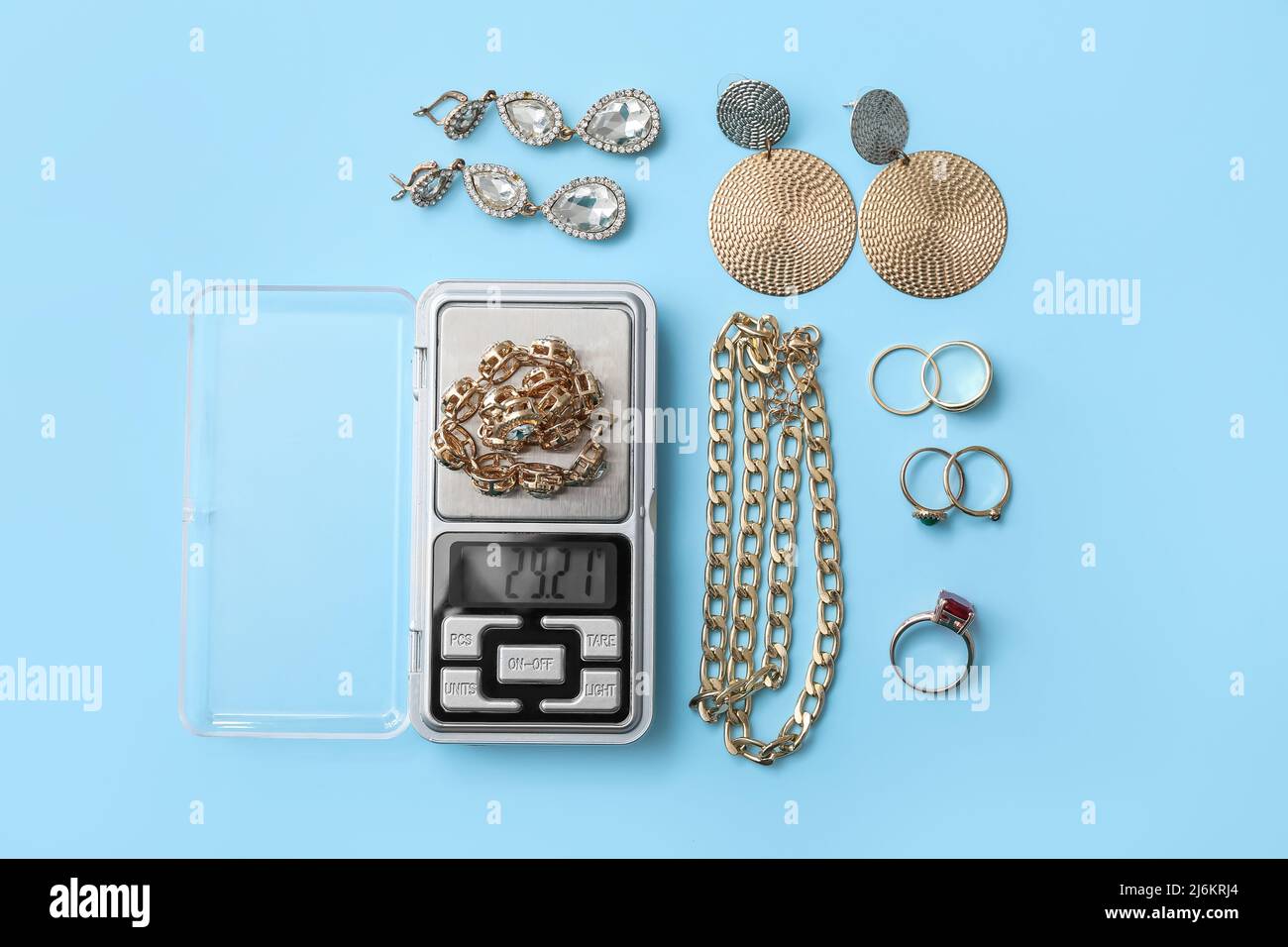 Different jewelry and scales on blue background Stock Photo - Alamy