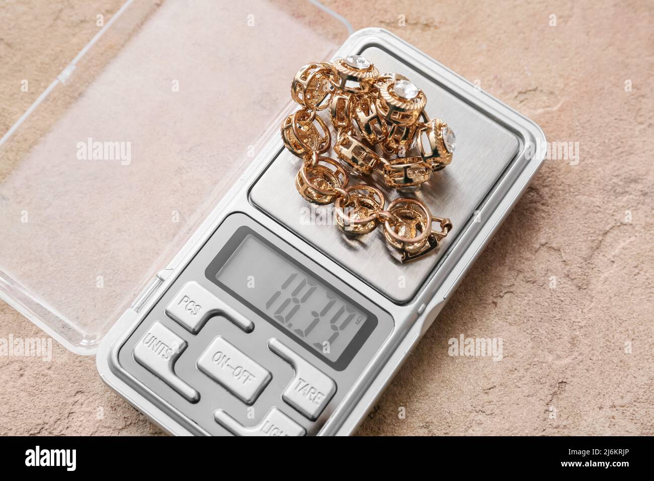 Jewelry scales with chain on beige background Stock Photo - Alamy