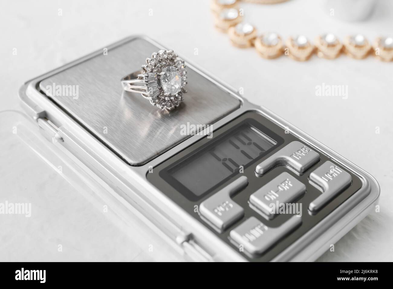 Jewelry scales with ring on white background Stock Photo - Alamy