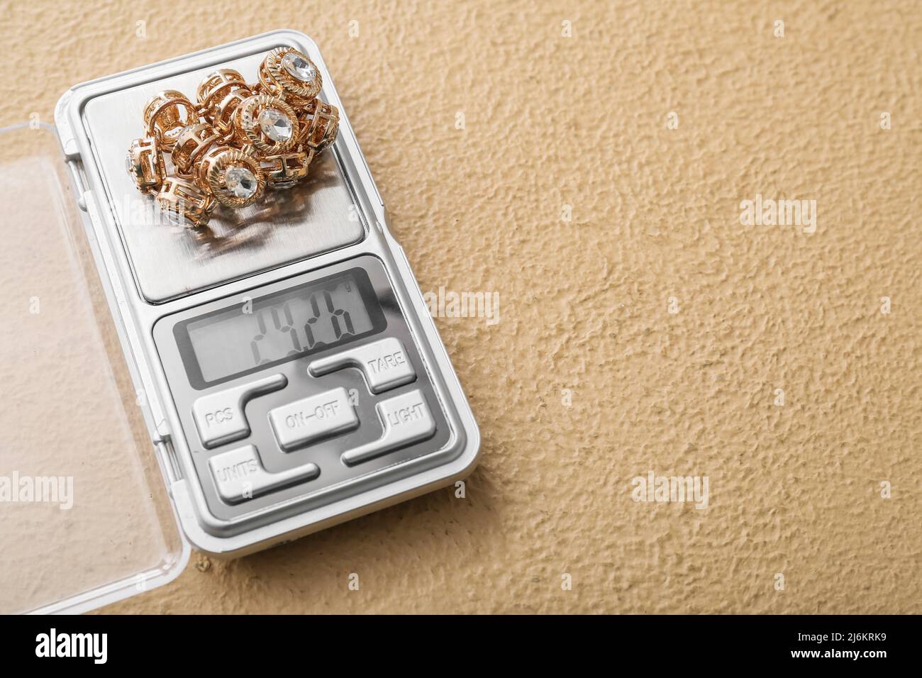 Jewelry scales with chain on beige background Stock Photo - Alamy