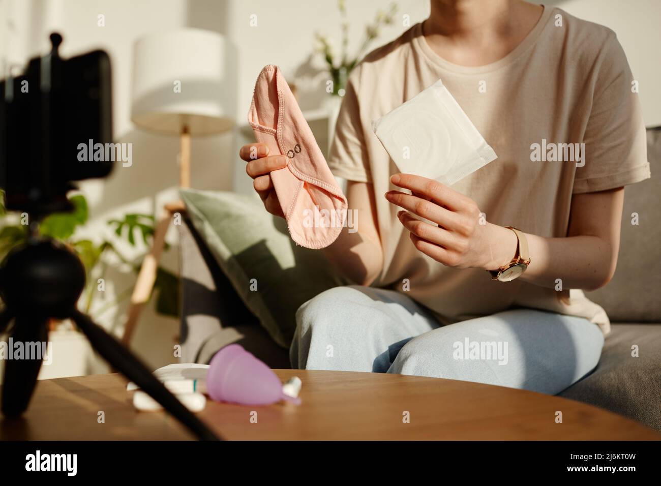 Minimal closeup of young woman holding pads to camera and filming ...