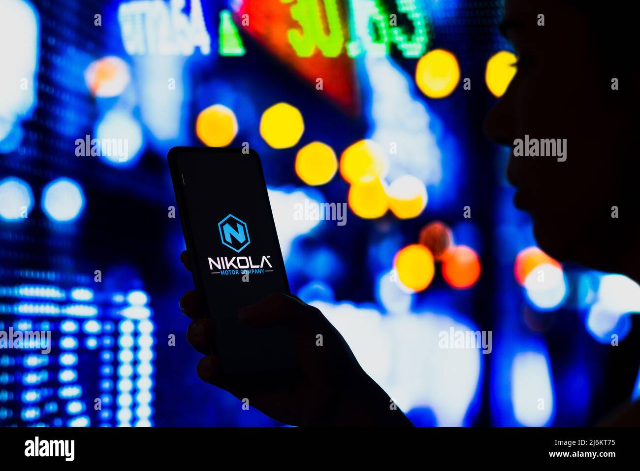 In this photo illustration, a silhouetted woman holds a smartphone with ...