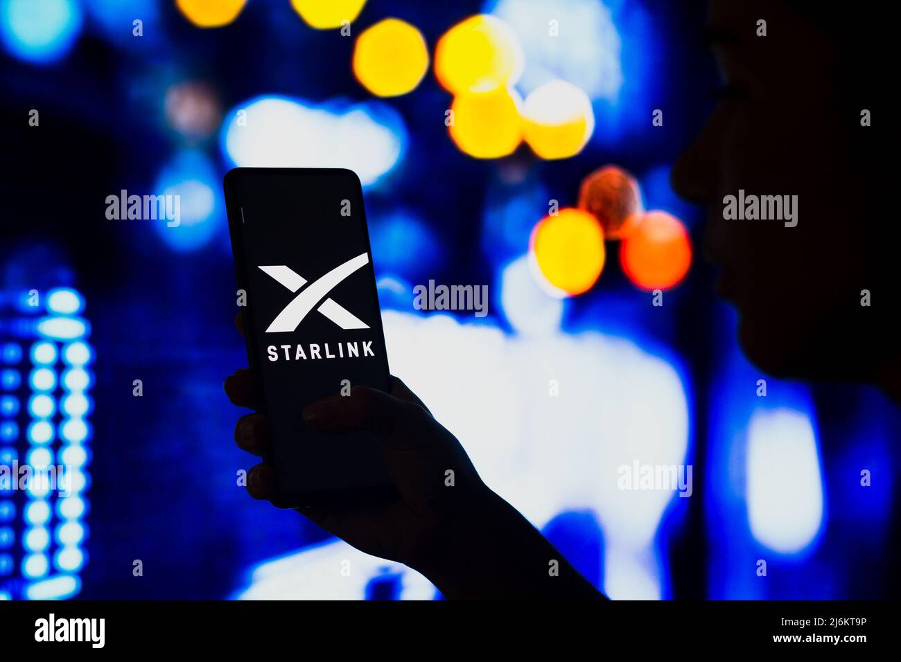 In this photo illustration, a silhouetted woman holds a smartphone with ...