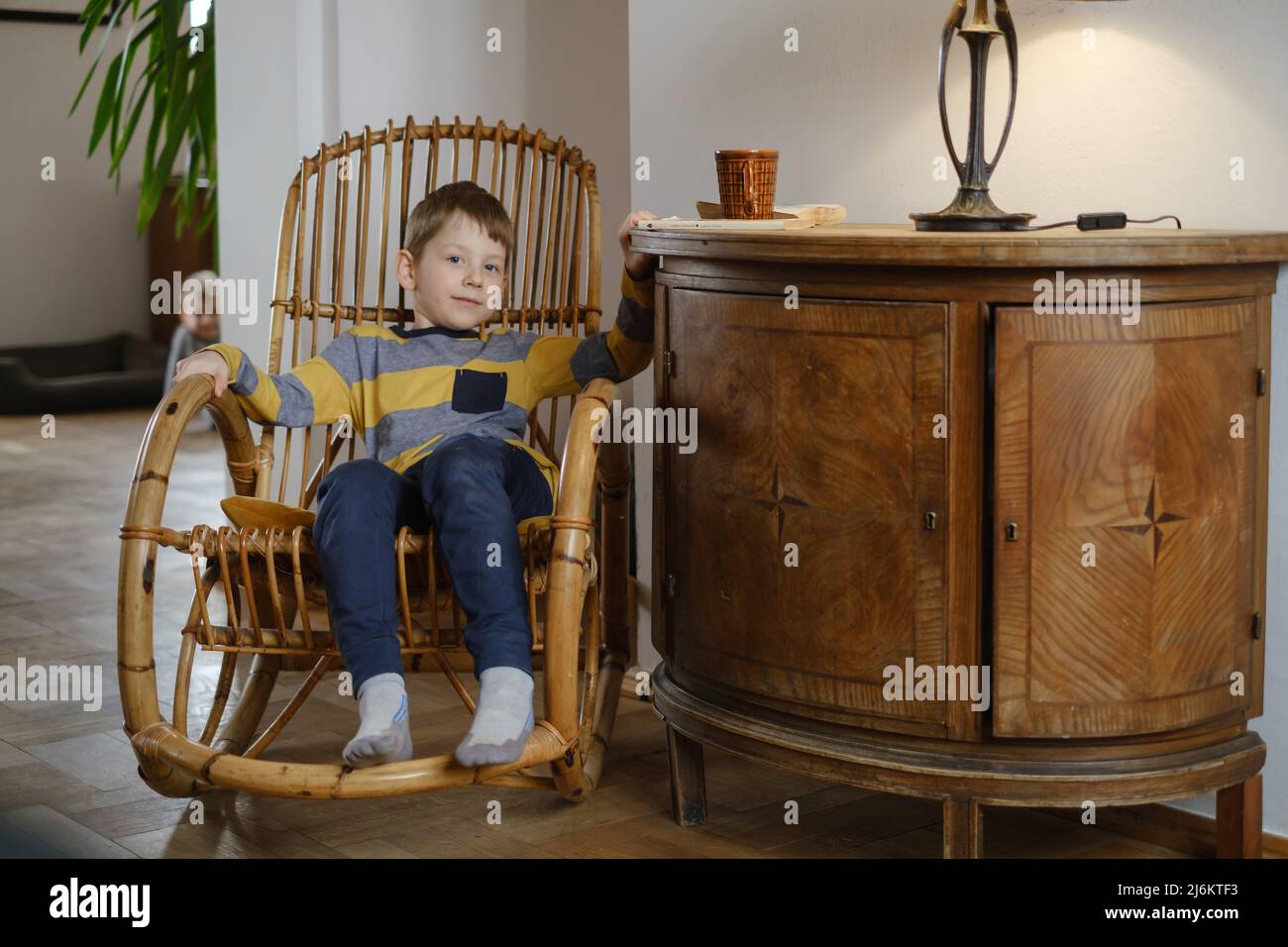 Child in rocking chair in vintage house. Retro home for family. Boy kid ...