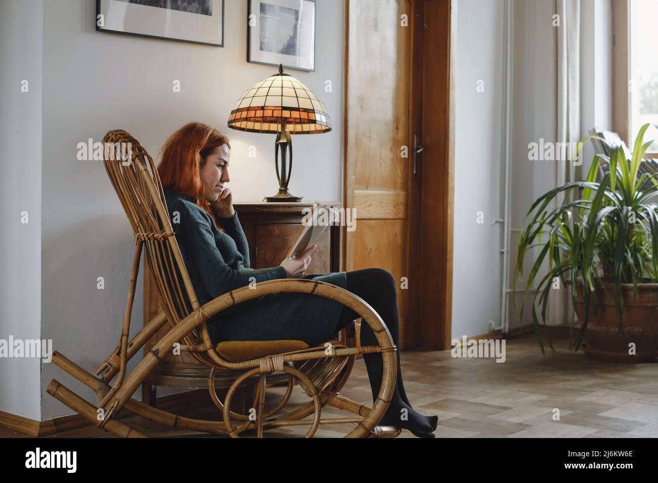 Woman on rocking chair reading book. Relaxed home atmosphere. Vintage ...