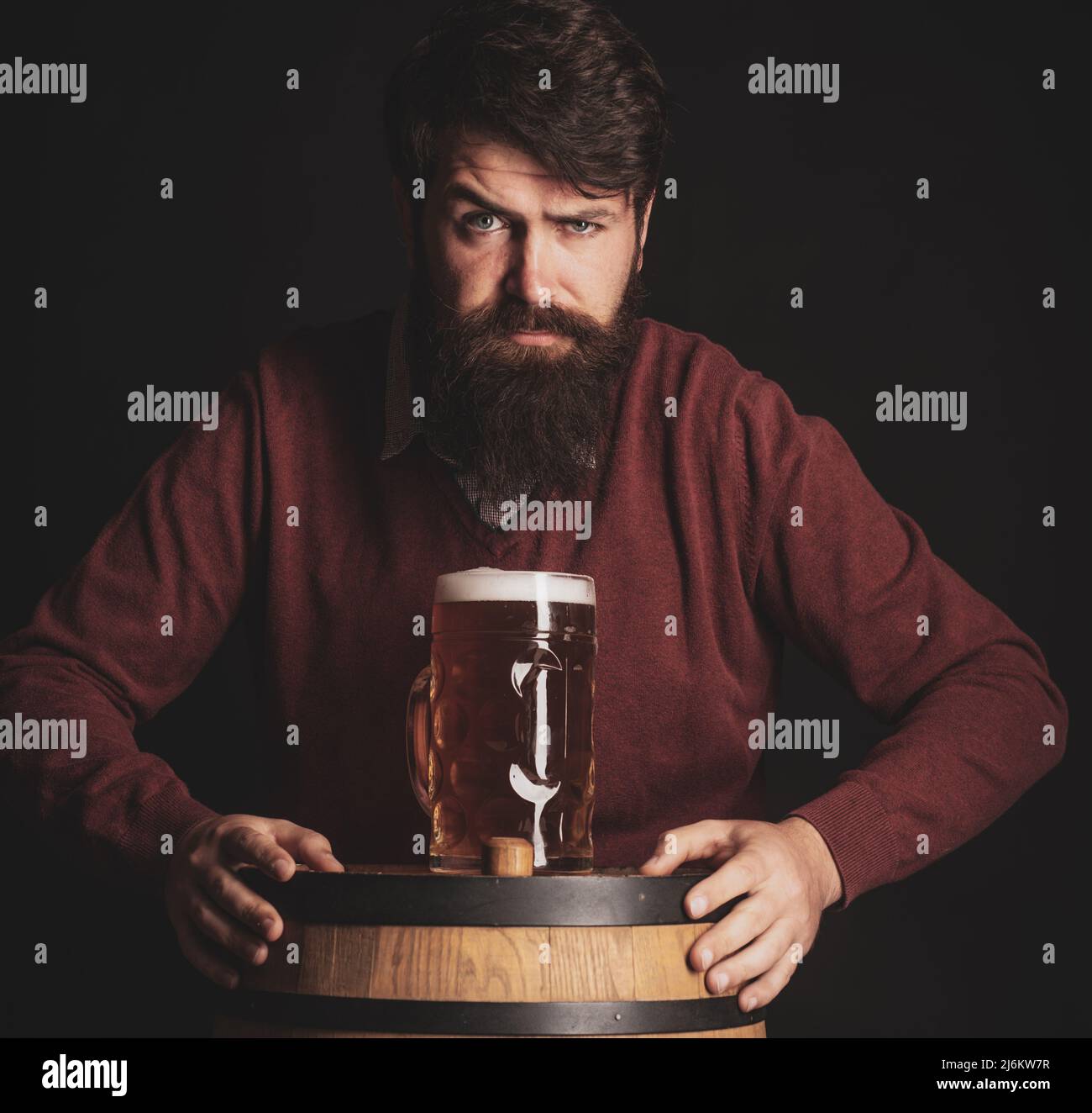 Stylish handsome man drinking beer over Black background. Brewer ...