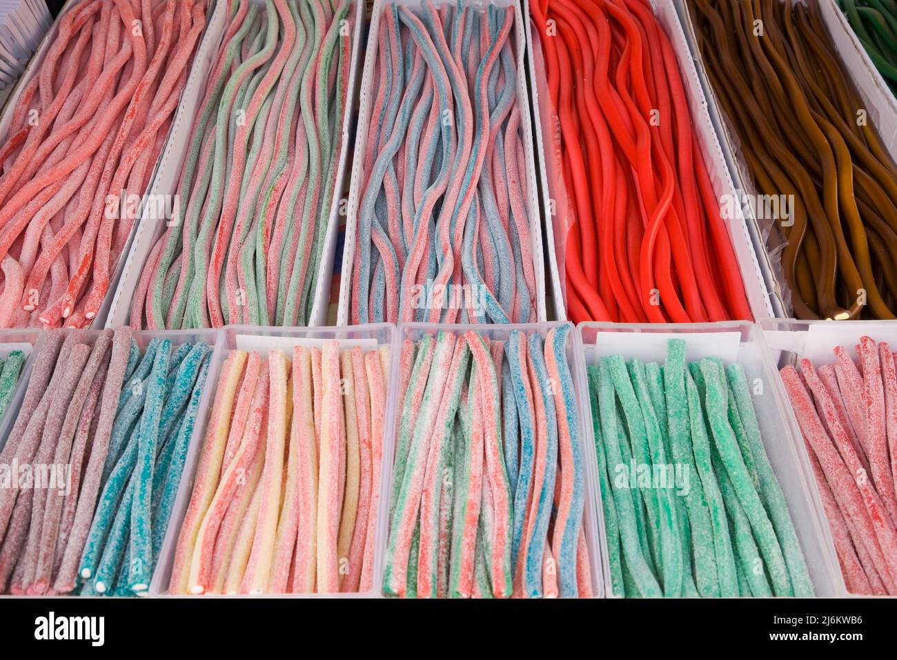 Baskets of assorted licorice sticks on display at an outdoor market ...