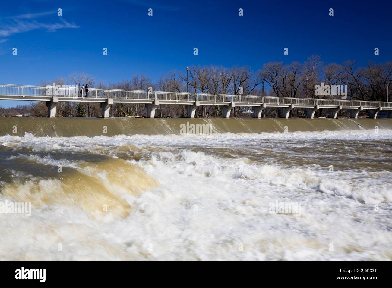 Footbridge and water flow control dam over the Mille-Iles river with a ...