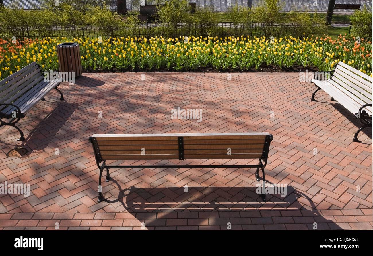 Wooden sitting benches in paving stone square surrounded by orange and ...