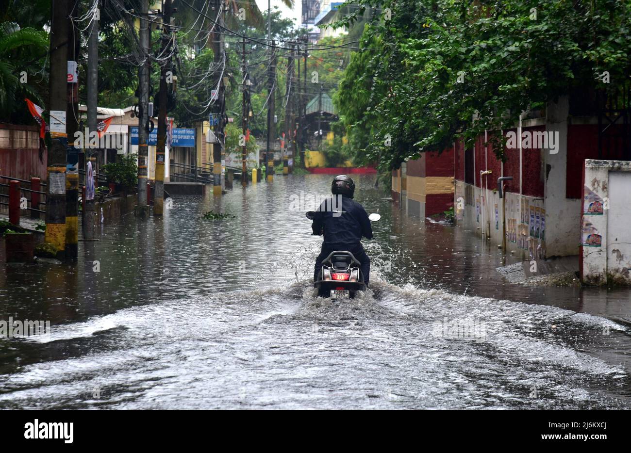 May 2, 2022, Guwahati, Assam, India: A motorcycle rider slowly wades ...