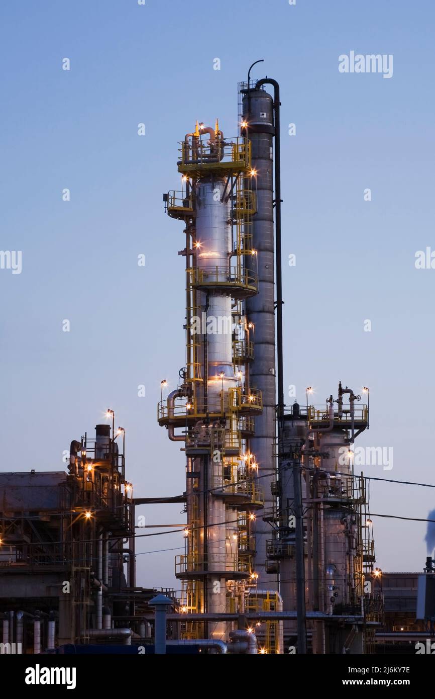 Illuminated smokestacks at an oil and gas refinery at dusk, Montreal ...